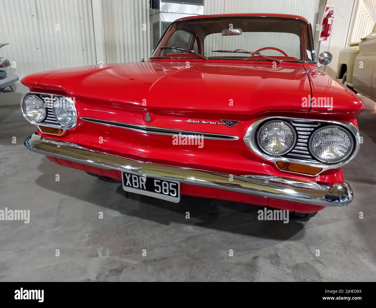 Old red Chevrolet Chevy Corvair Monza coupe 1963 in a warehouse. Front ...