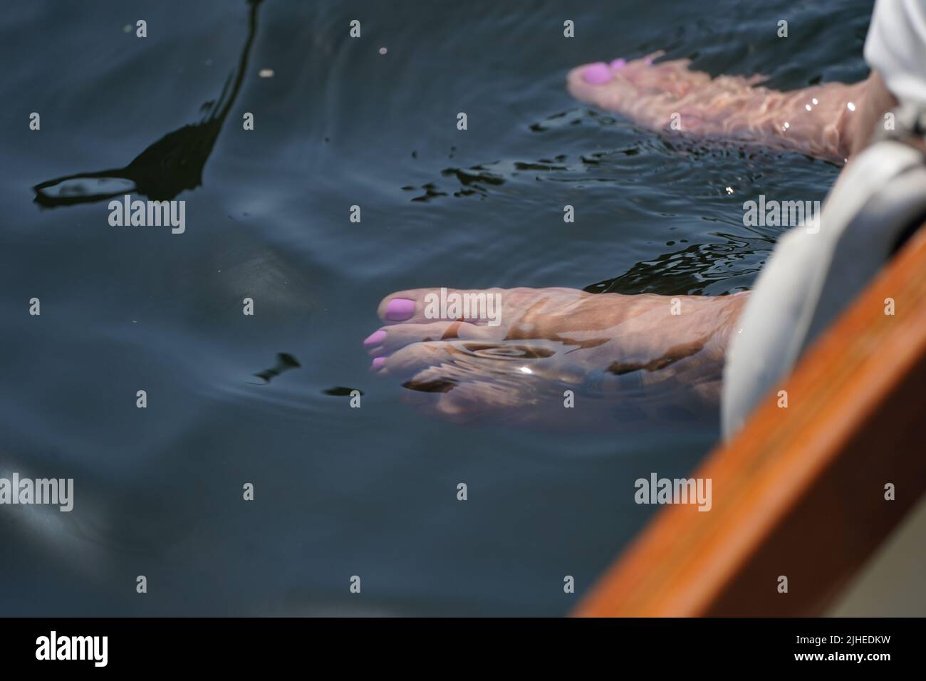 A woman keeping cool by dipping her feet in the River Thames near ...