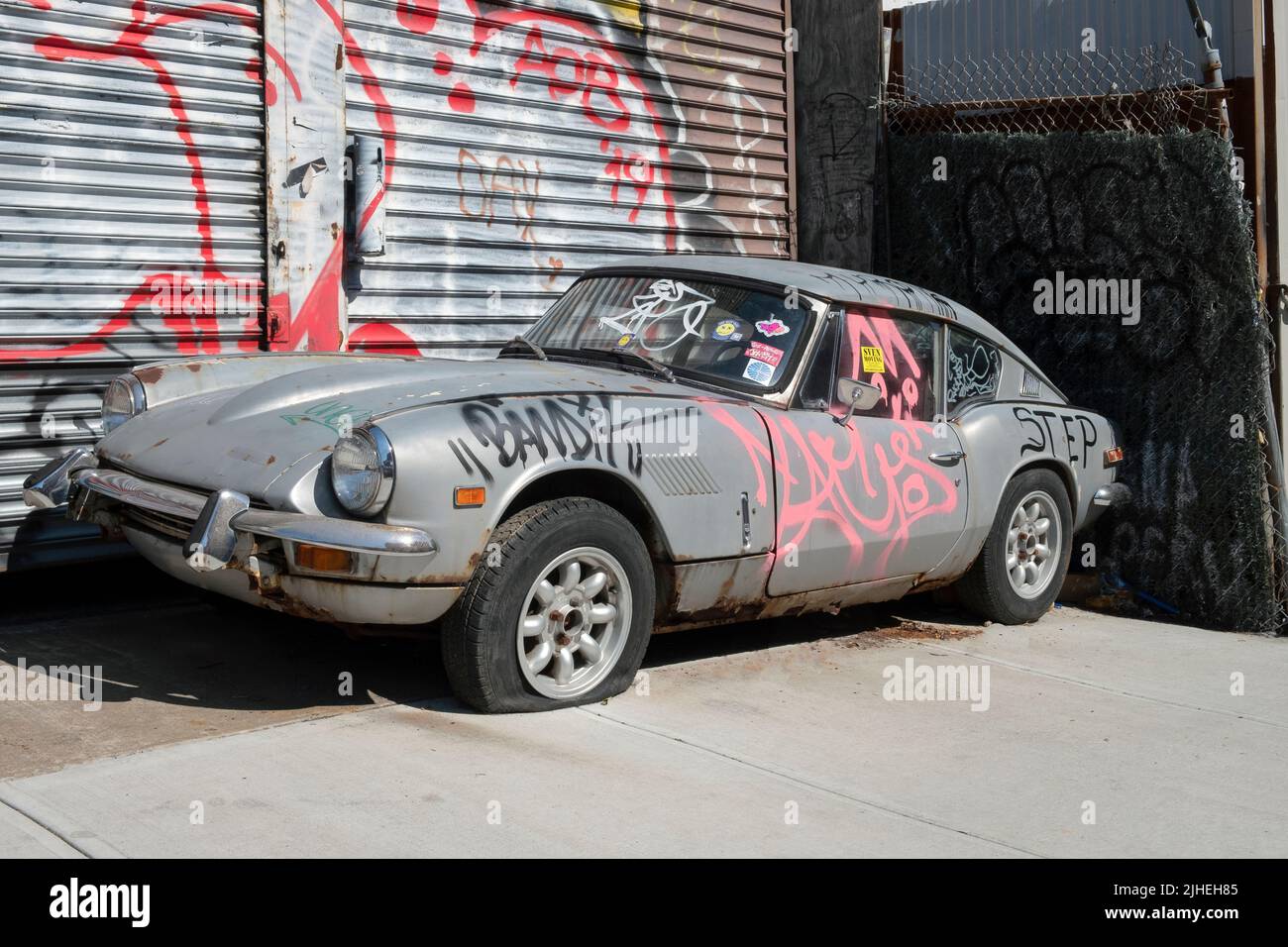 URBAN LANDSCAPE. A graffitied and recked Jaguar sedan on Roebling ...
