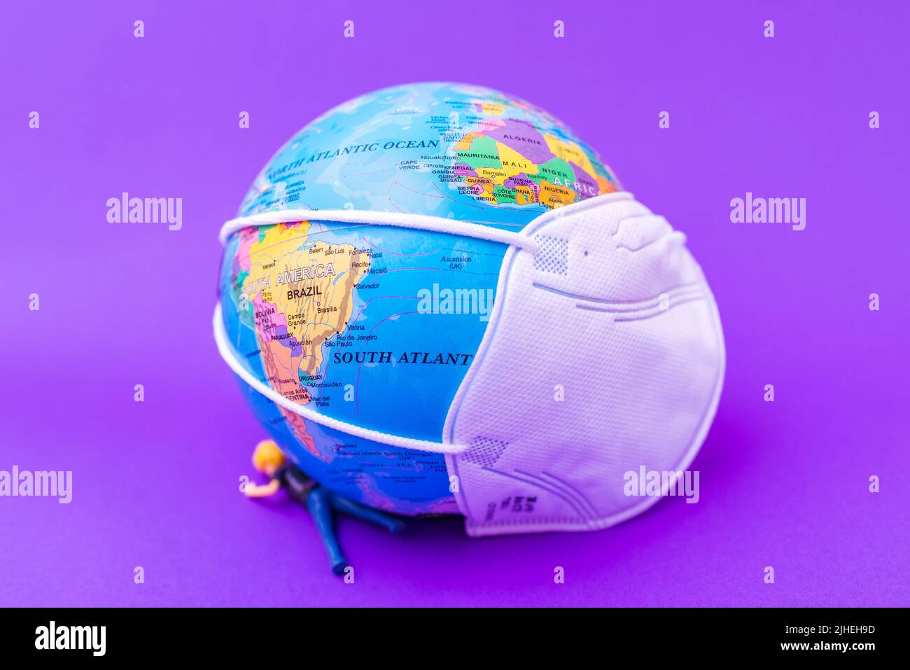 World Planet Earth with face mask protect,miniature toy girl is pressed ...