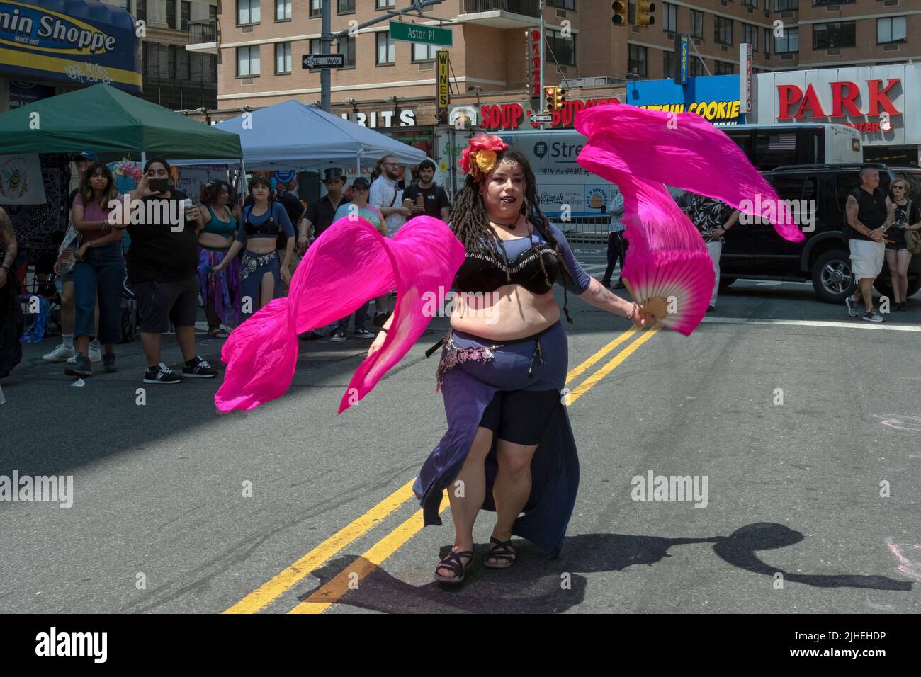 A belly dancer waving colorful fabrics dances at Witchsfest 2022 on ...