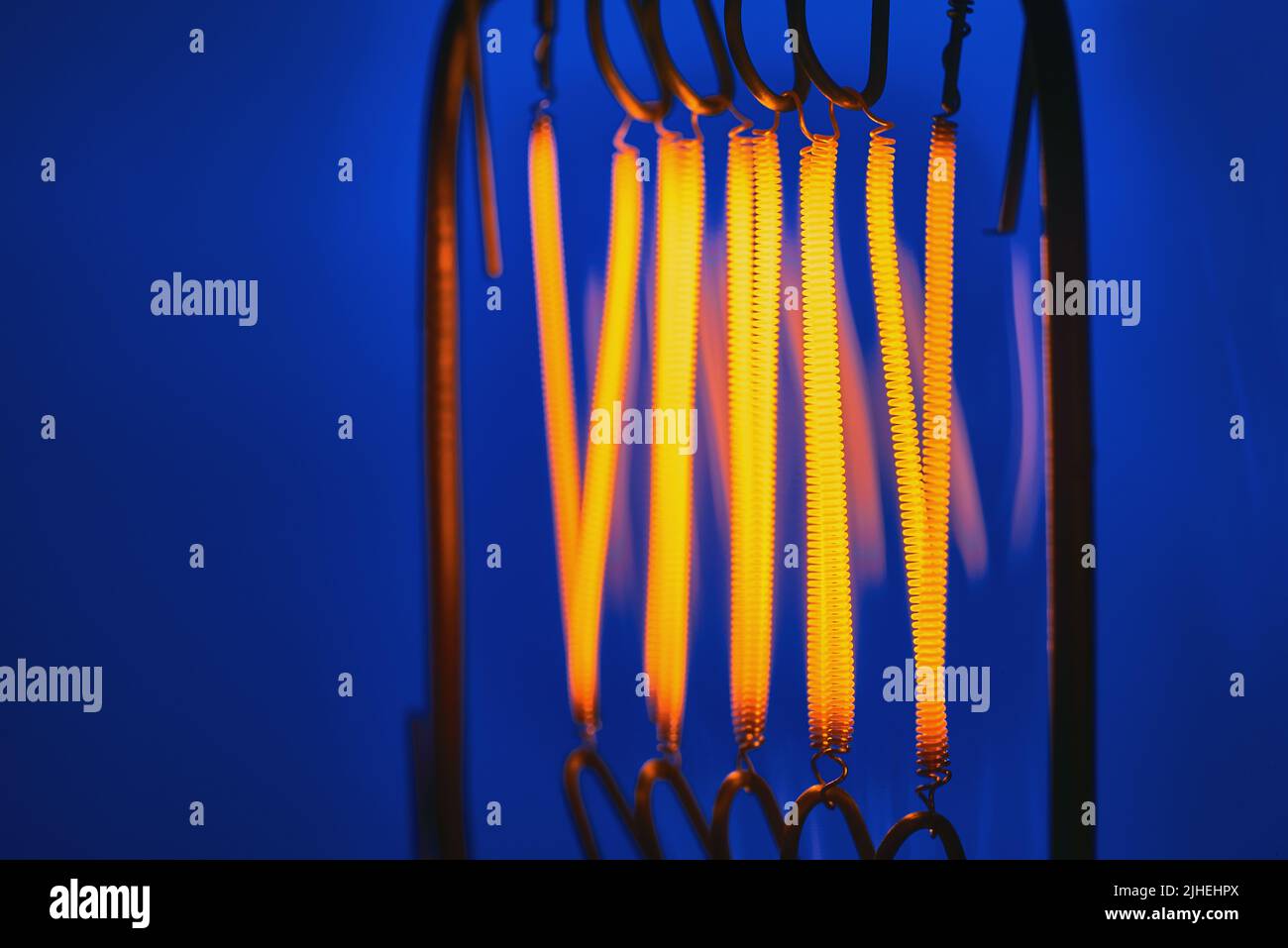 tungsten filament of high power incandescent lamp on blue background ...