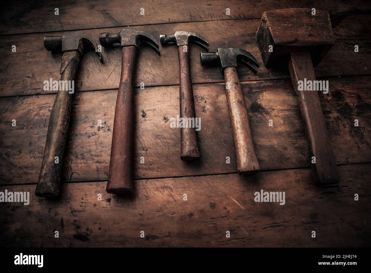 collection of carpentry rusty old tools, hammers on top of workbench ...