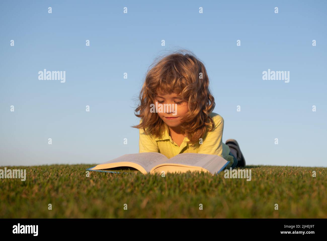 Outdoor portrait of a clever little boy reading a book Stock Photo - Alamy
