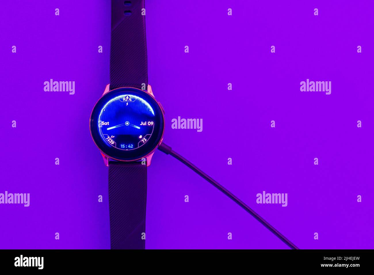 Smart watch on wireless charging with on-screen.Purple,veri peri neon ...