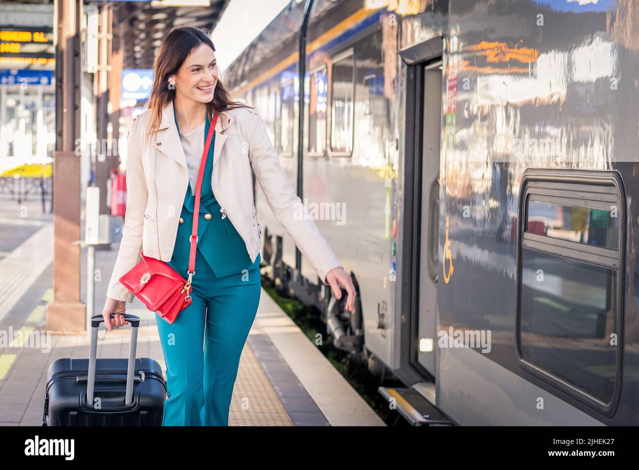 Beautiful girl running and chasing the leaving train in station. Waving ...