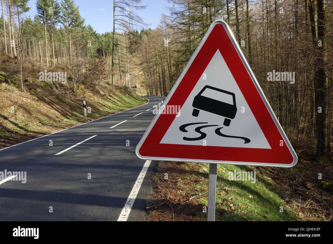 The slippery road warning sign by the countryside road Stock Photo - Alamy