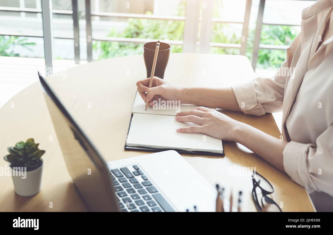 new normal, a businesswoman useing notebook and computer to work for a ...