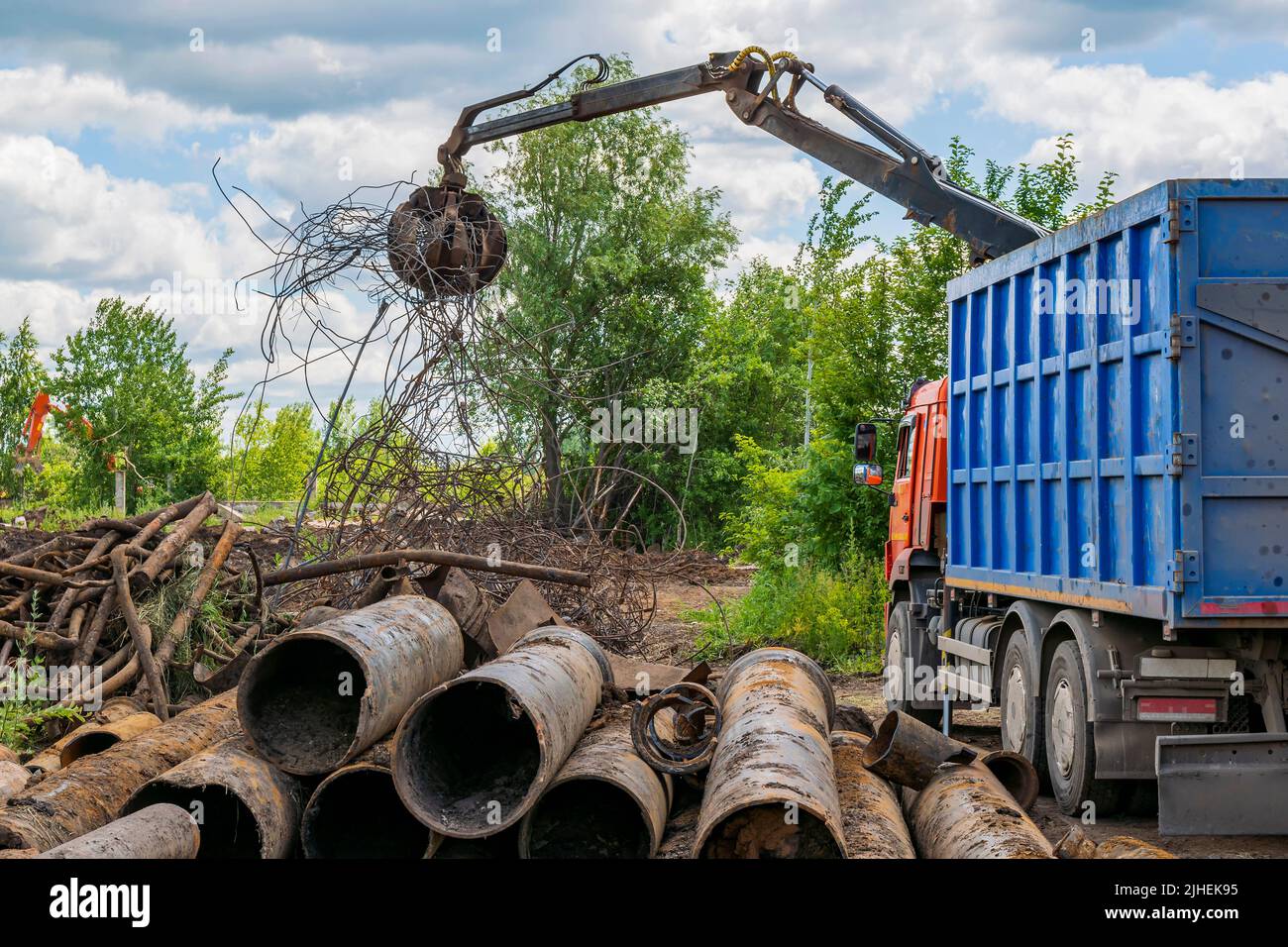 Scrap metal waste (steel and cast iron pipes) is loaded into truck ... Scrap metal waste (steel and cast iron pipes) is loaded into truck ...