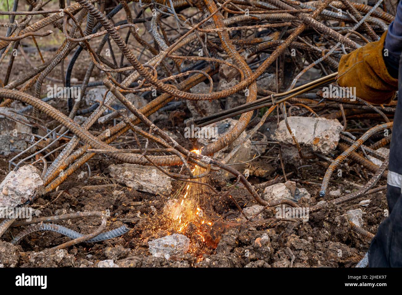 Welder using gas burner cuts metal waste (scrap fittings) for ...