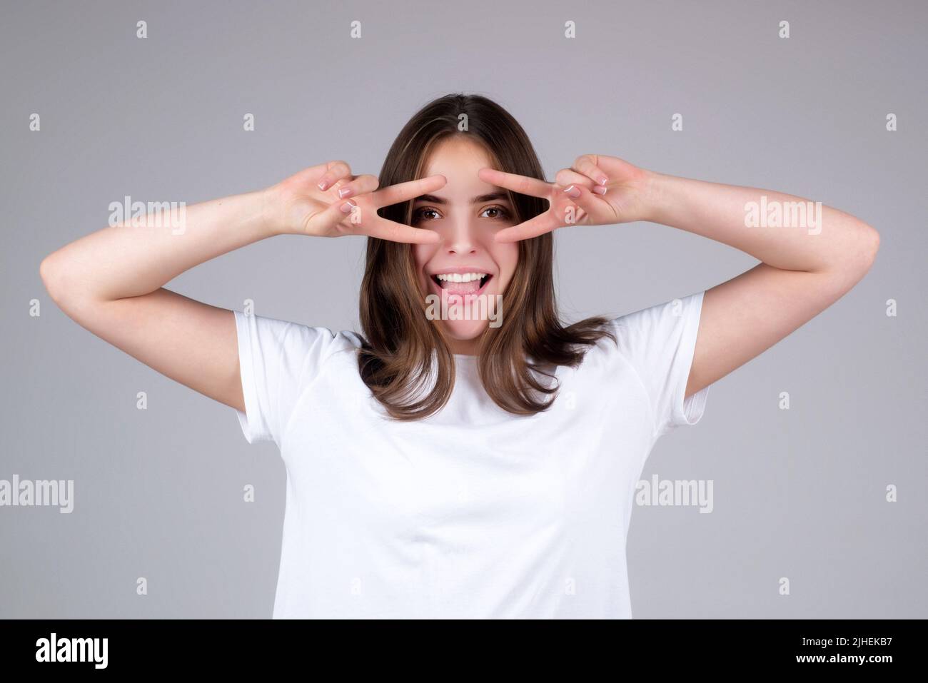 Funny woman with finger eyes. Close up portrait of beautiful female ...