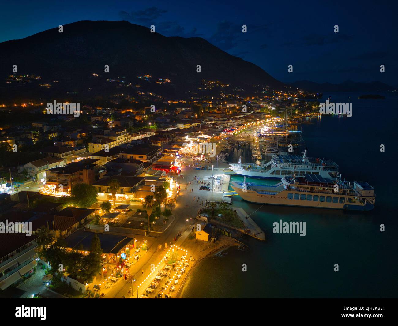 An aerial view of illuminated seaside Nydri town in Lefkada, Greece at ...