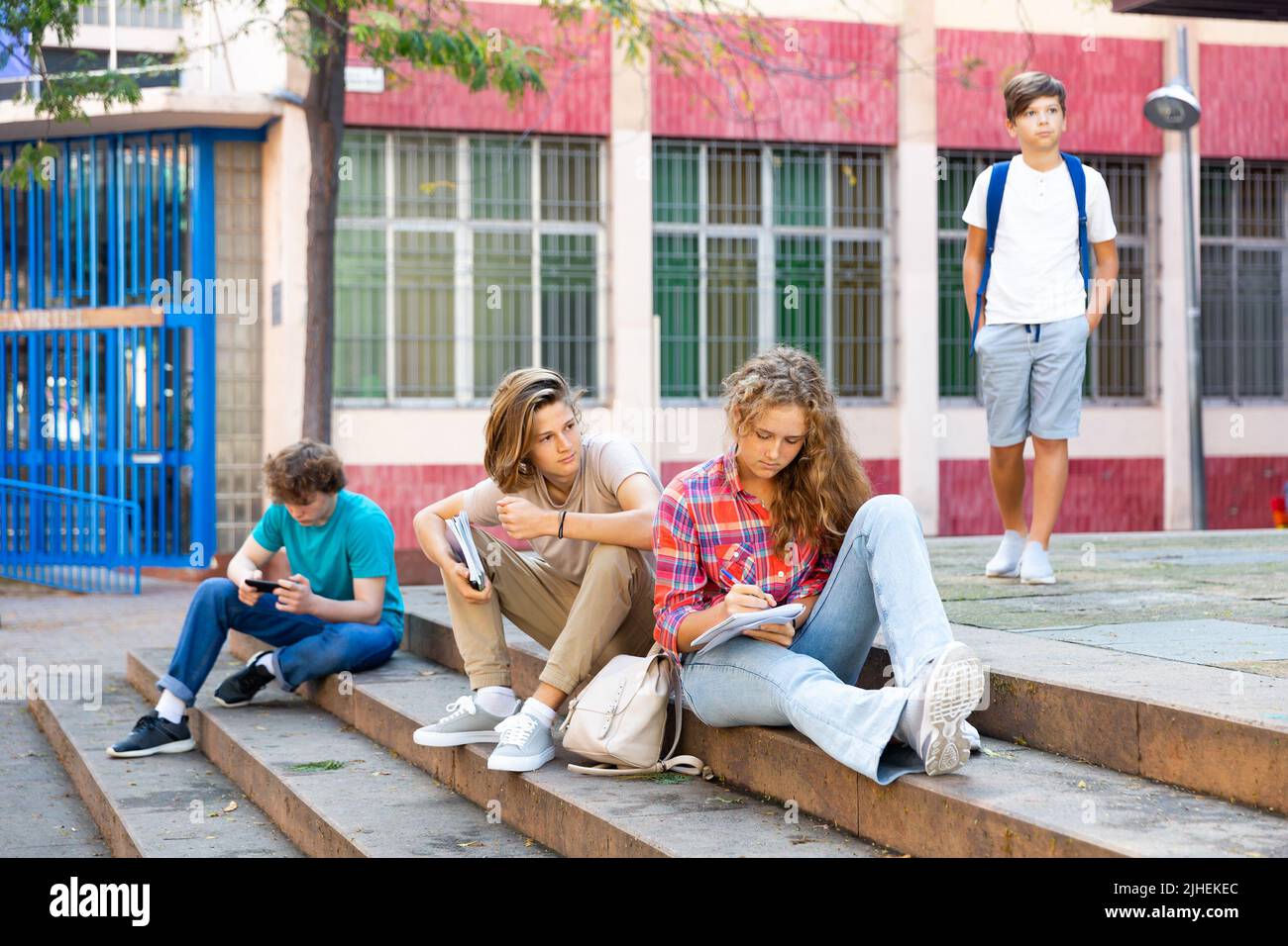 Upset girl in front of her friends after quarrel on street Stock Photo ...