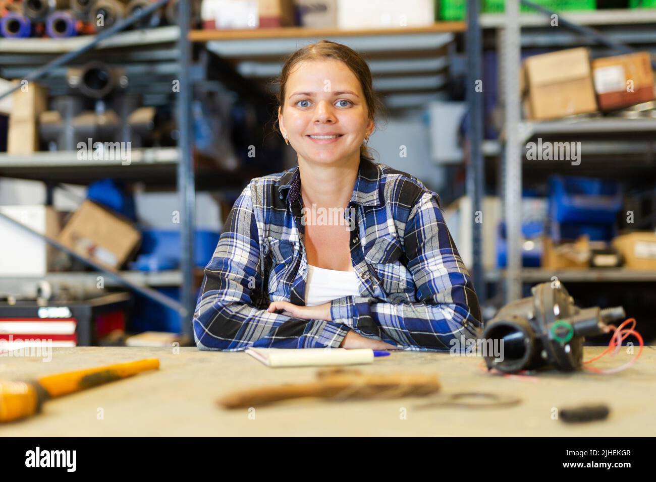 Satisfied female employee of hardware store posing in warehouse Stock ...