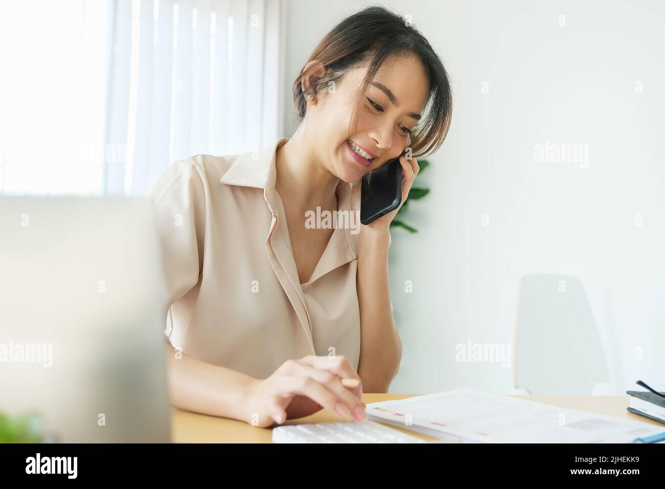 new normal, a businesswoman using computer and smartphone to work for a ...