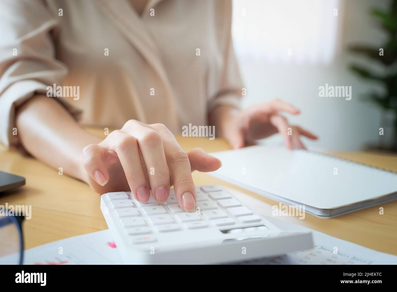 Business woman using calculator to review balance sheet annual using ...