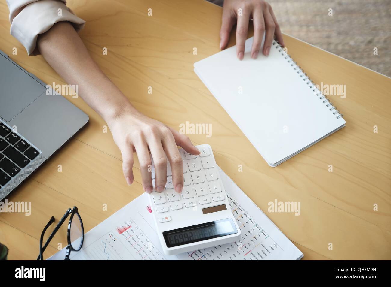 Business woman using calculator to review balance sheet annual using ...
