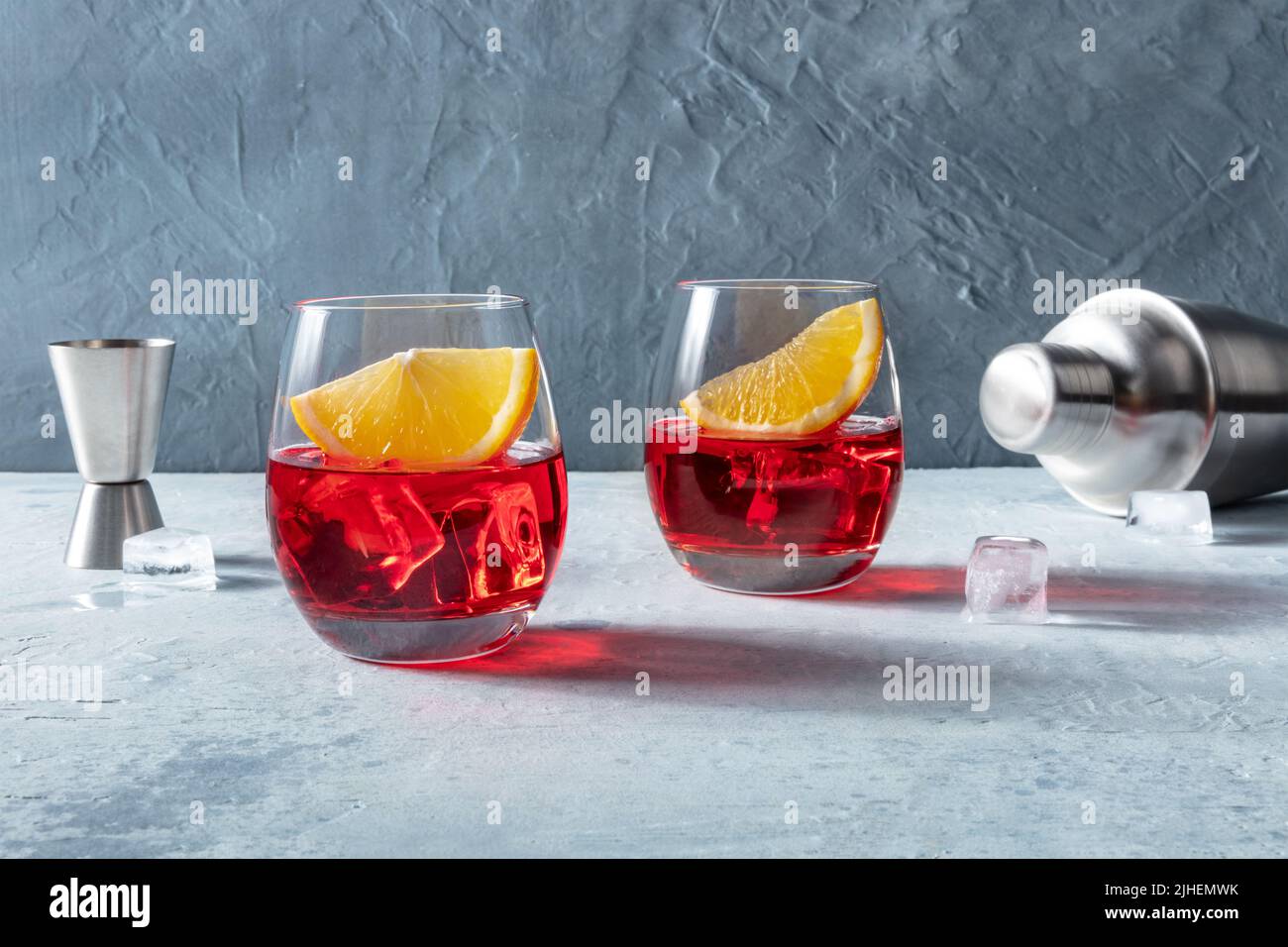 Campari aperitif with fresh orange slices, a jigger and a shaker. A ...