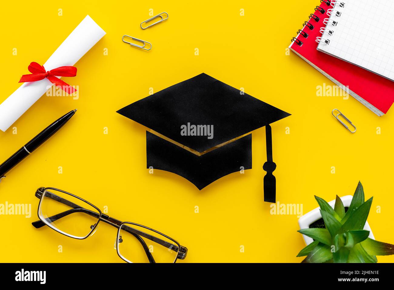 Graduation at the university concept. Academic cap on students table ...