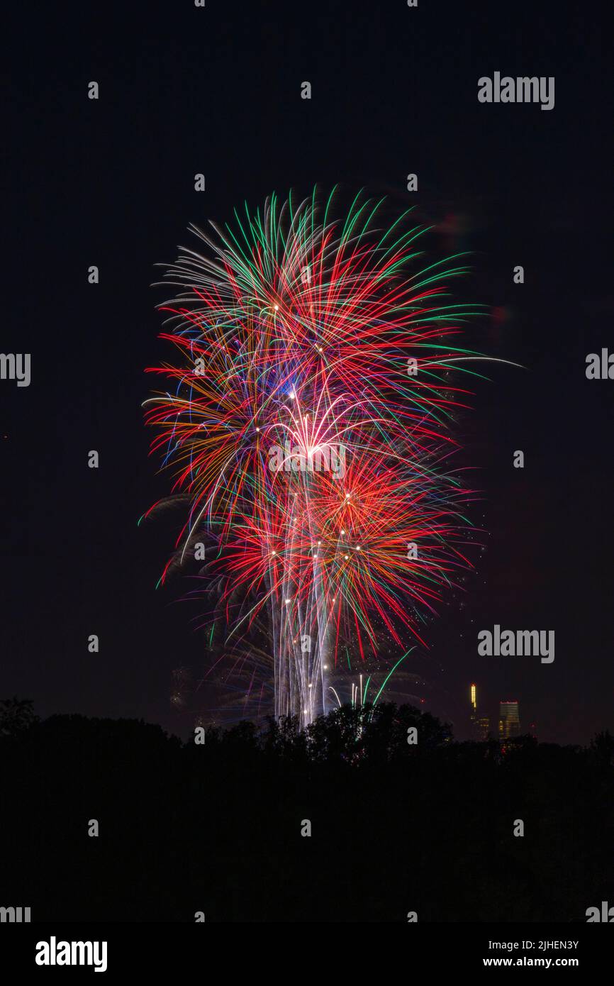 A vertical shot of vibrant red and green fireworks illuminating the ...