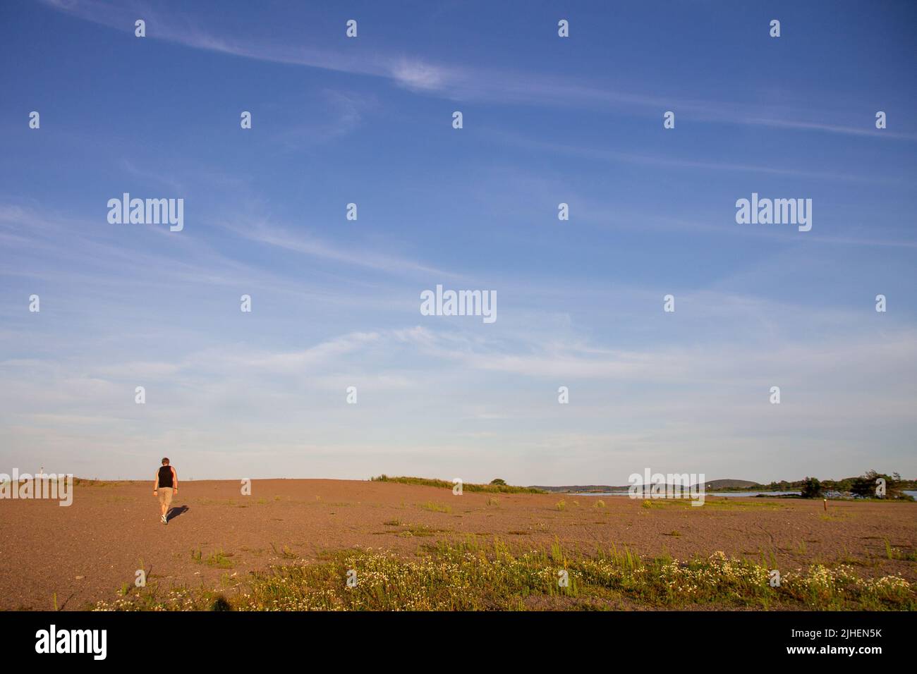A man walking in the hot dessert on a clear day Stock Photo - Alamy