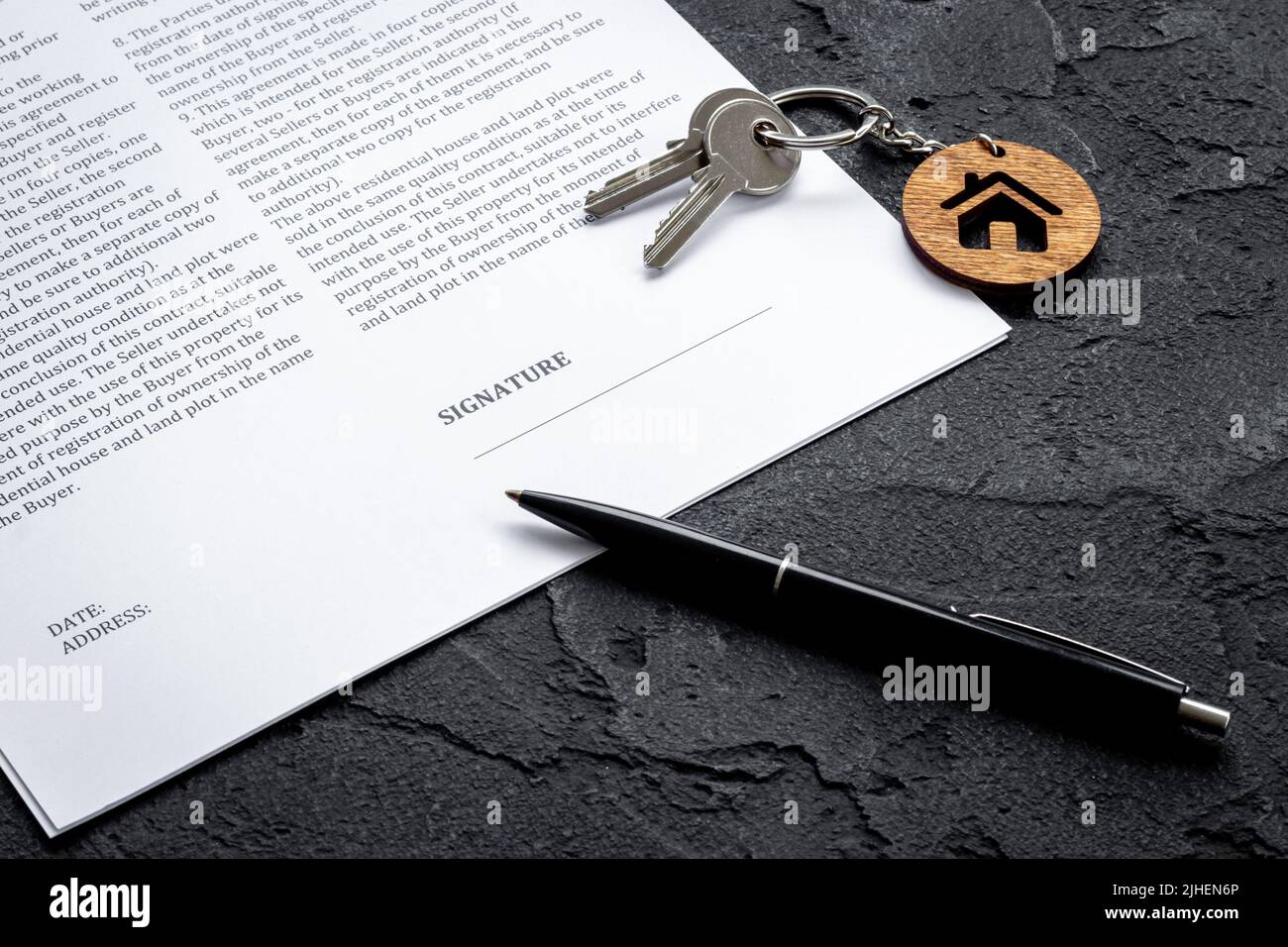 Signing a house purchase agreement with house shaped keychain Stock ...