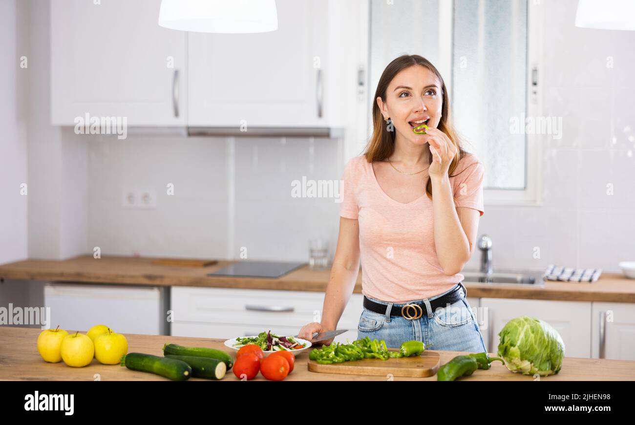 Woman cooking and tasting pepper at kitchen Stock Photo - Alamy