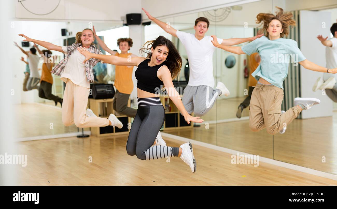 Group of cheerful sportive teenagers jumping in dance hall Stock Photo ...