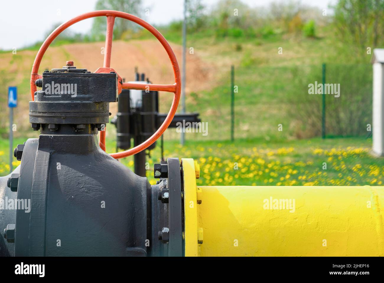 Two black and yellow gas pipes are connected by large bolts.Background ...