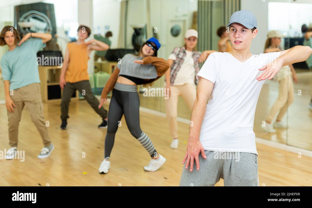 Teen b-boy dancing with group of friends in dance studio Stock Photo ...