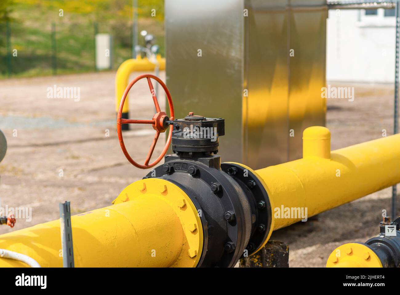 Two black and yellow gas pipes are connected by large bolts.Background ...