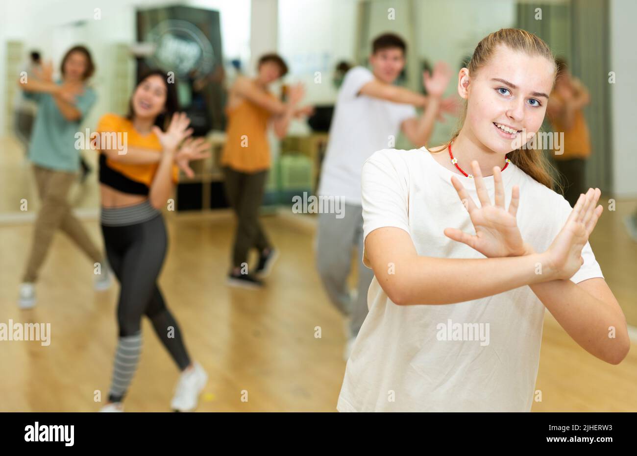 Teen girl performing modern dance with her mates in studio Stock Photo ...