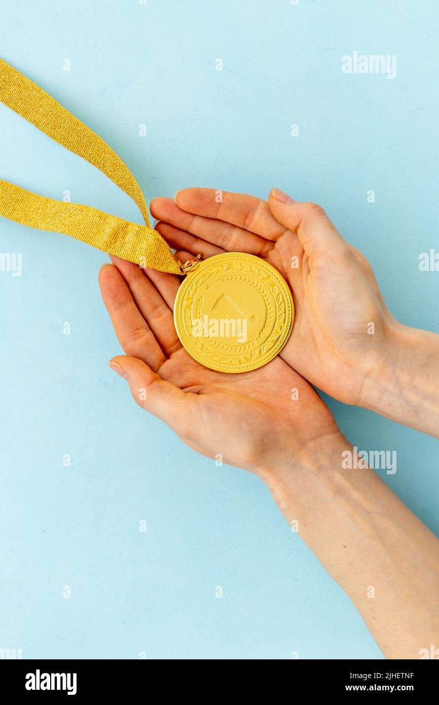 Hand holding gold medal first place. Winner of competition concept ...