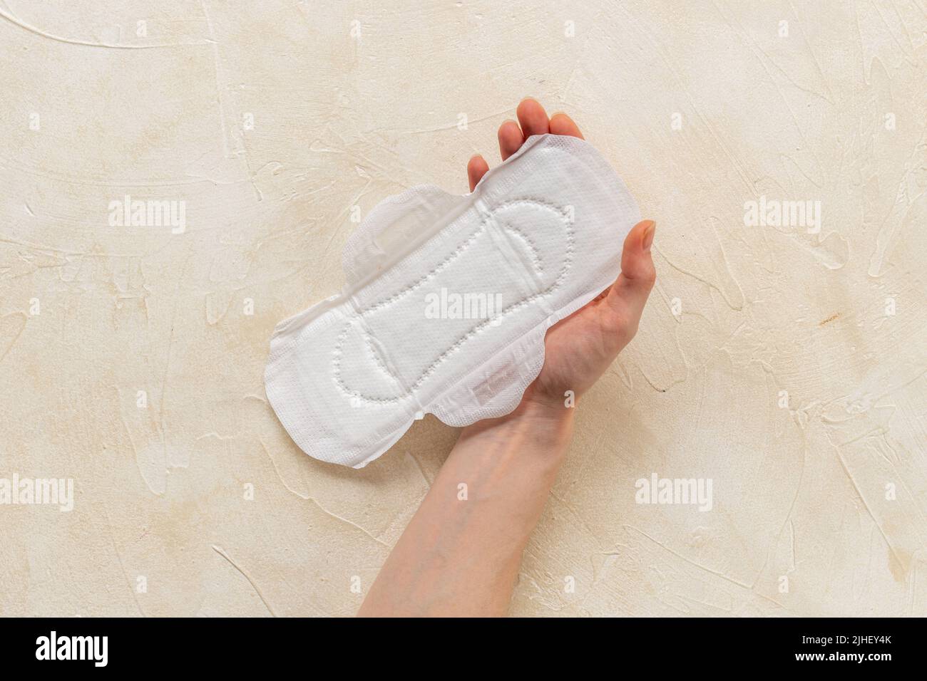 White pad in female hand. Menstruation period and daily hygiene concept ...