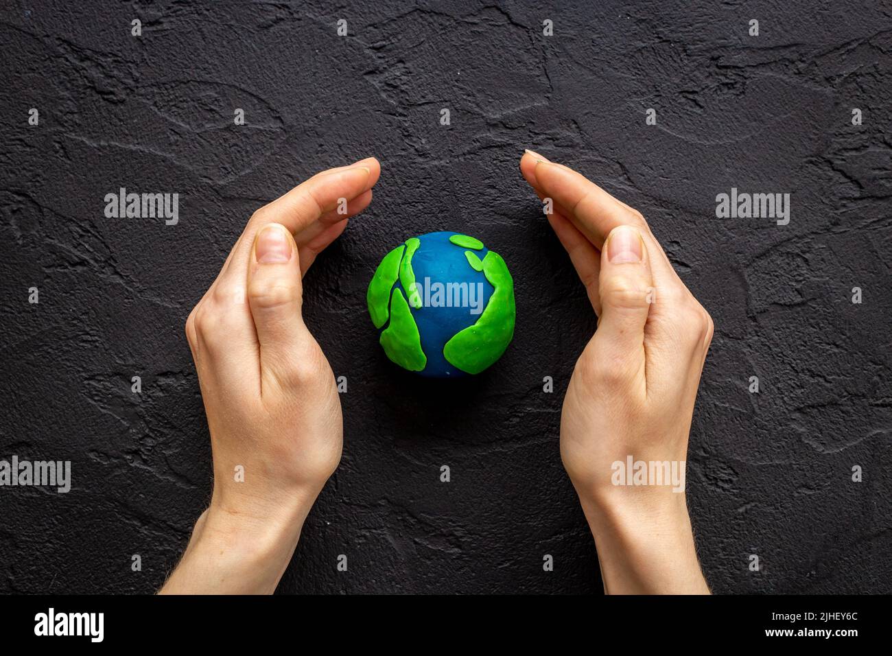 Plasticine world - planet Earth in hands. Eco care concept Stock Photo ...