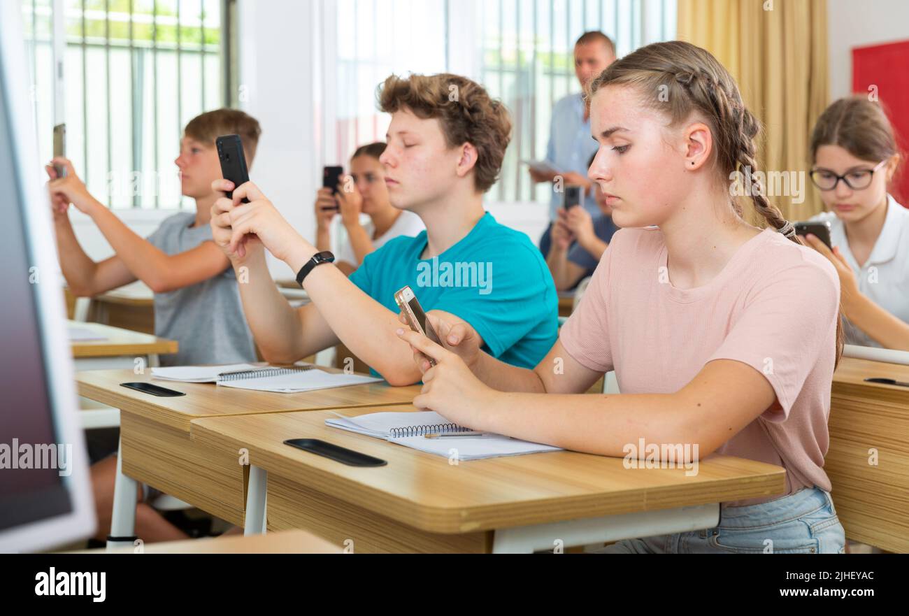 Teen girl student using smartphone while studying in college Stock ...