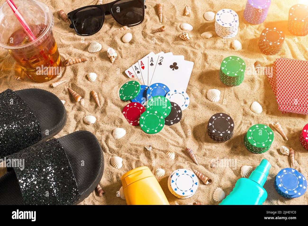 Beachpoker. Chips and cards on the sand. Around the seashells ...