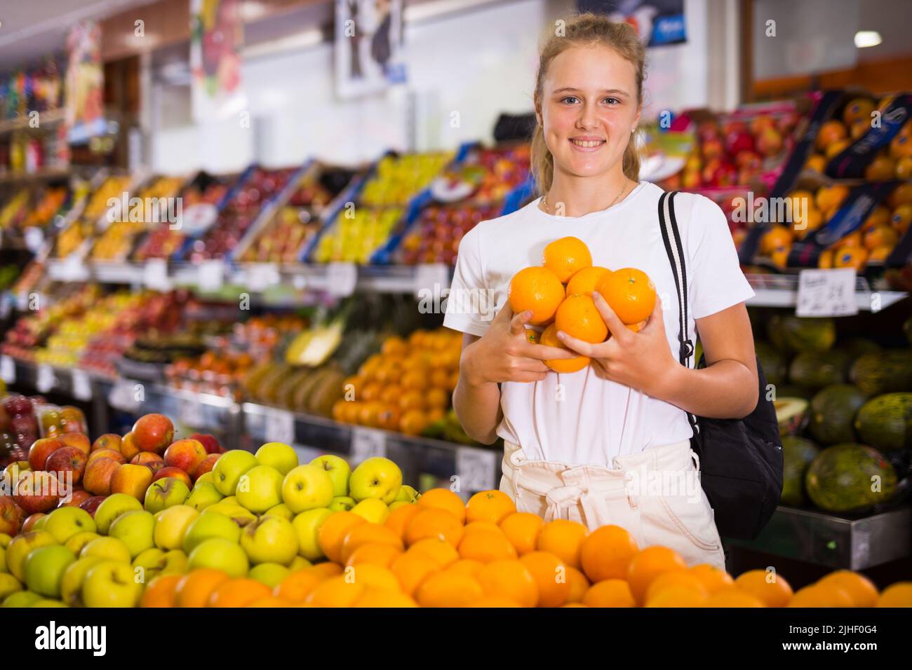 Girl consumer choosing oranges at supermarket Stock Photo - Alamy