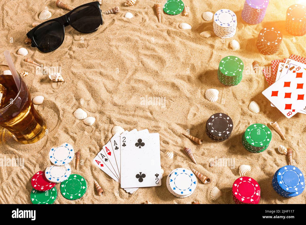 Beachpoker. Chips and cards on the sand. Around the seashells ...