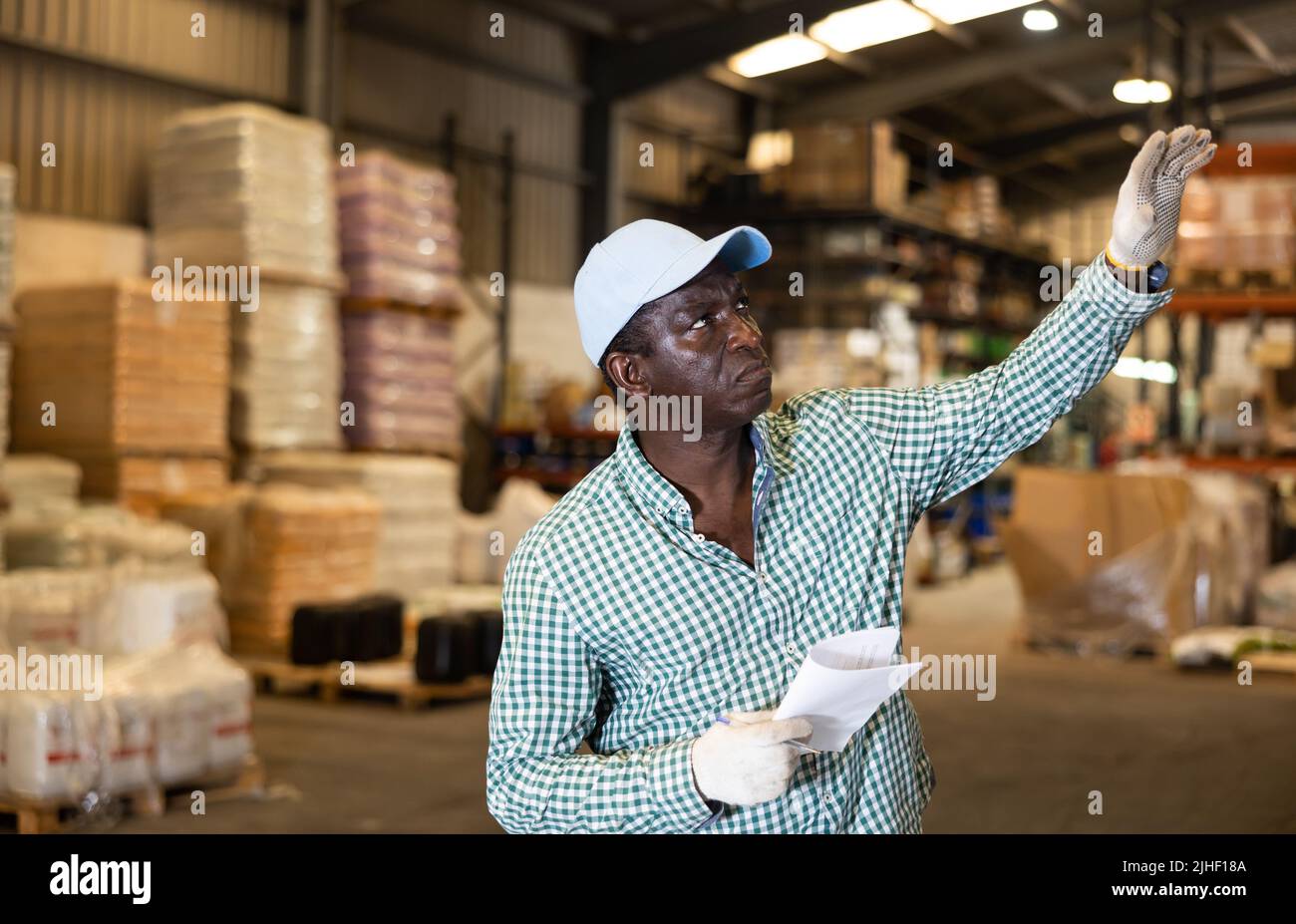 Male warehouse worker making hand gesture Stock Photo - Alamy