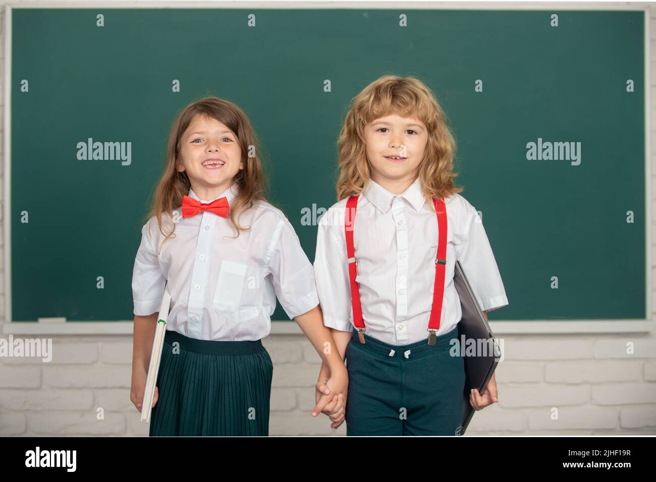 Cute little school kids friends studying together in classroom ...
