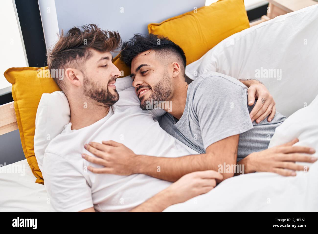 Young couple hugging each other lying on bed at bedrooom Stock Photo ...