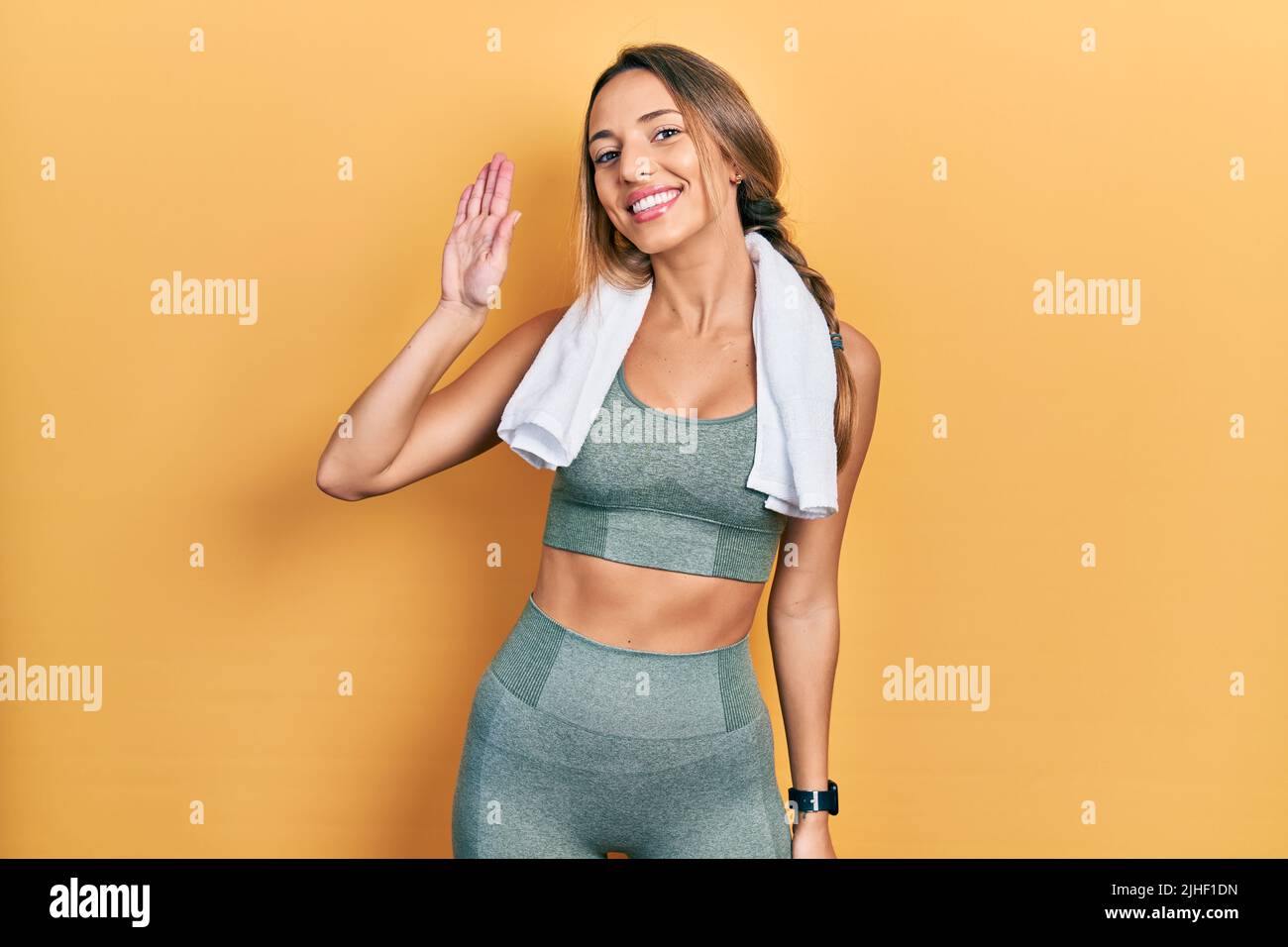 Beautiful hispanic woman wearing sportswear and towel waiving saying ...
