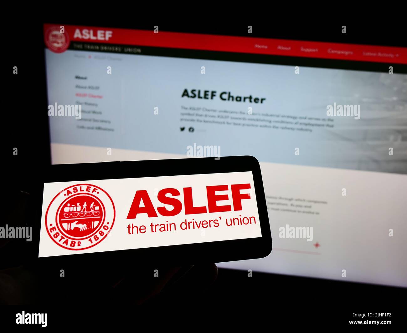 Person holding mobile phone with logo of British trade union ASLEF on ...