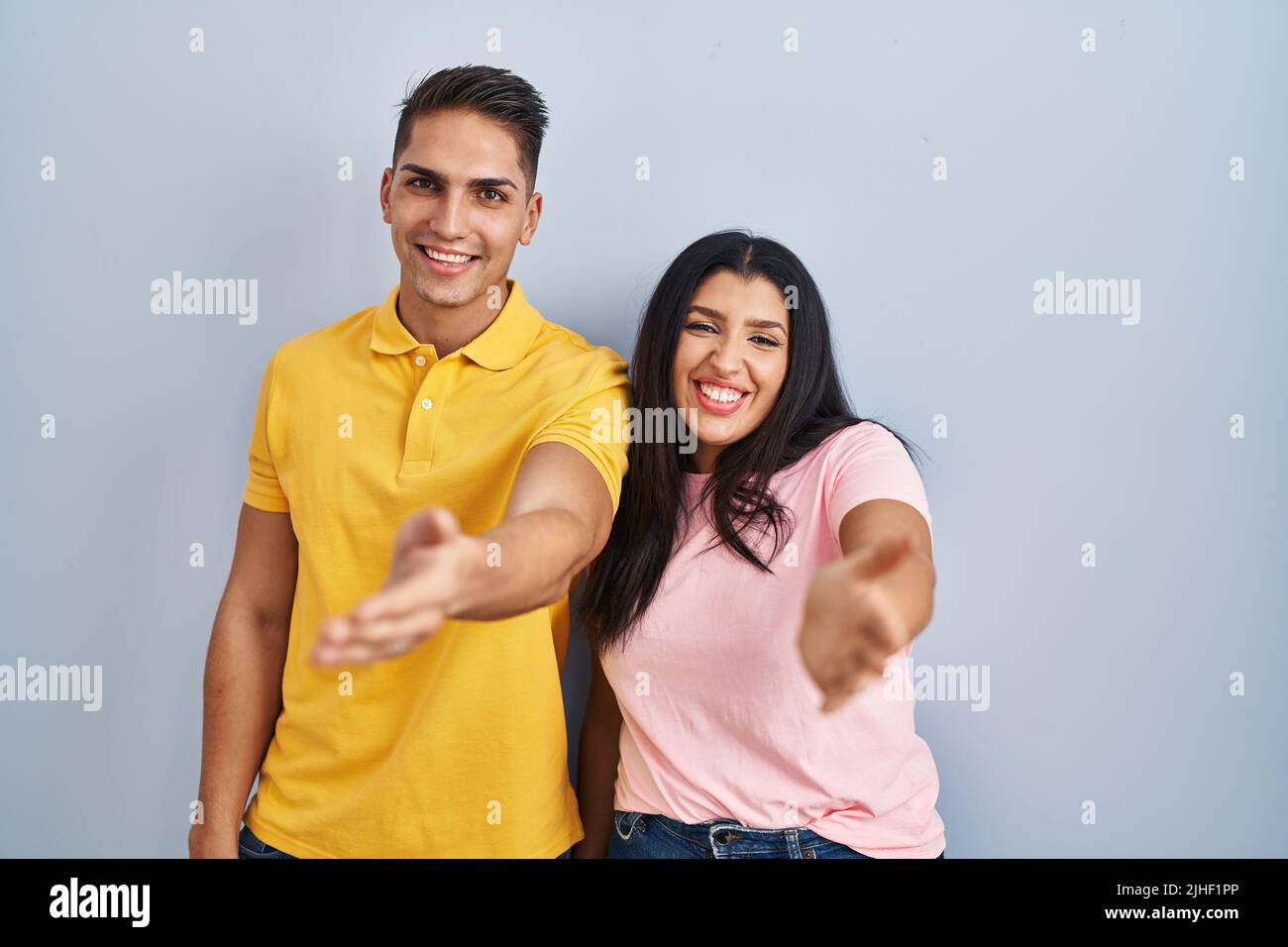 Young couple standing over isolated background smiling cheerful ...
