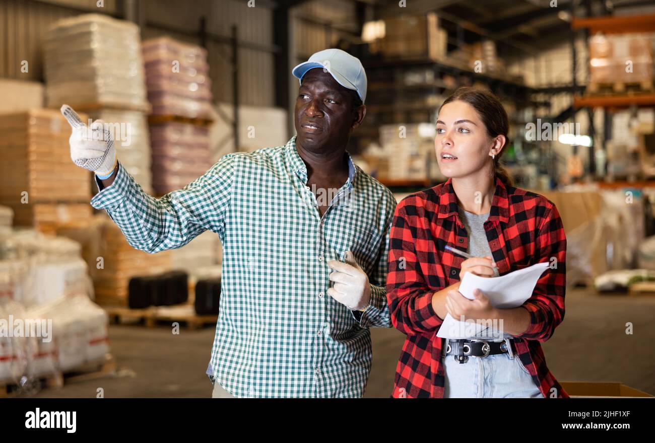 Man and woman working in warehouse, talking about job Stock Photo - Alamy