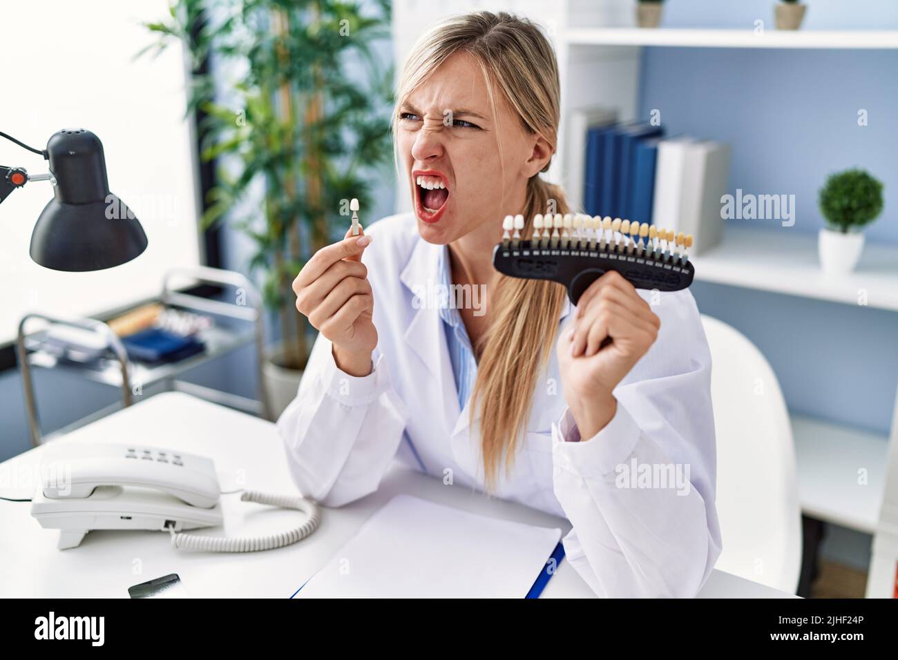 Beautiful dentist woman comparing teeth whitening angry and mad ...