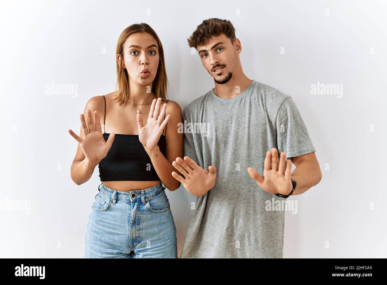 Young beautiful couple standing together over isolated background ...