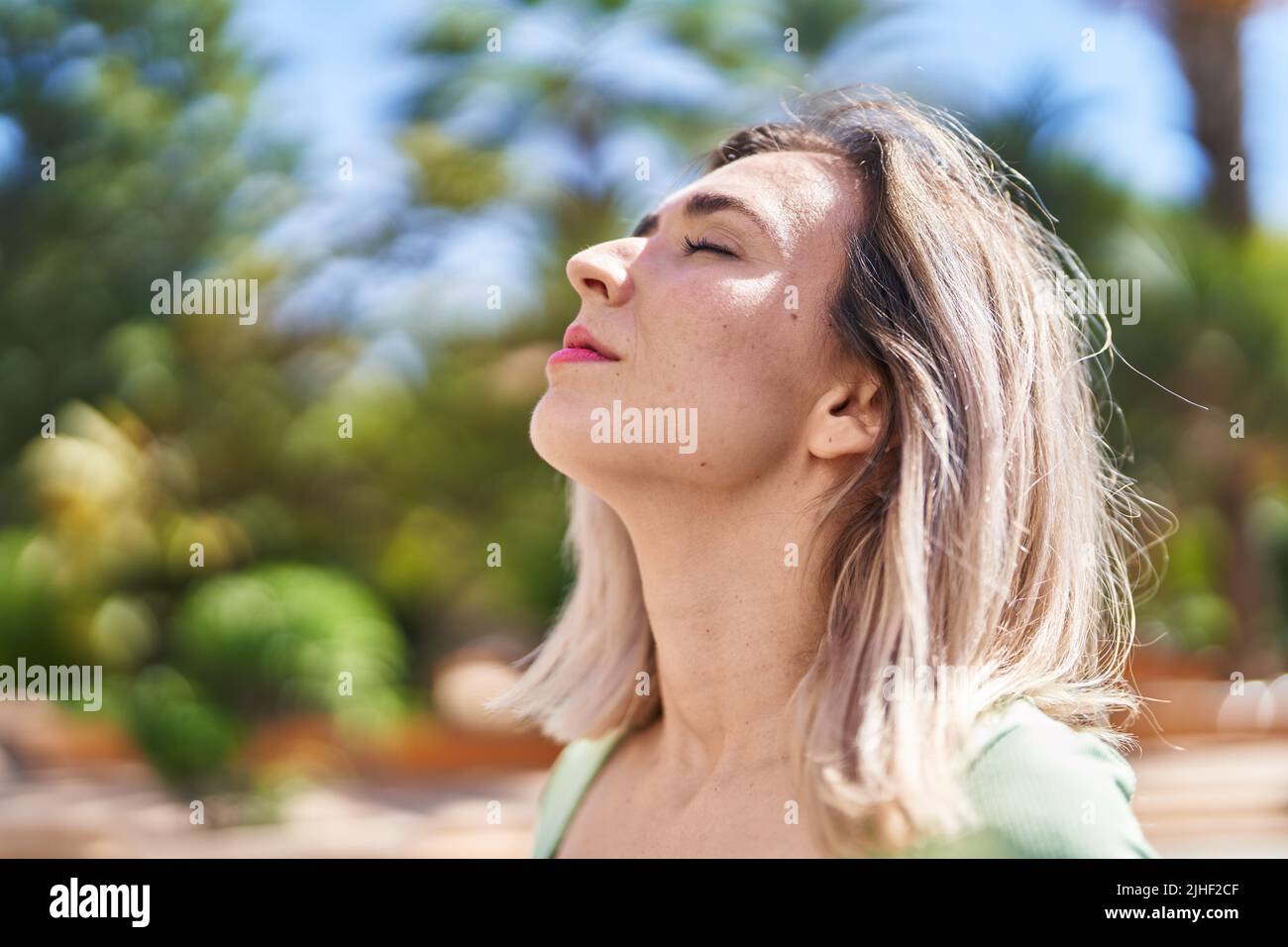 Young woman breathing at park Stock Photo - Alamy
