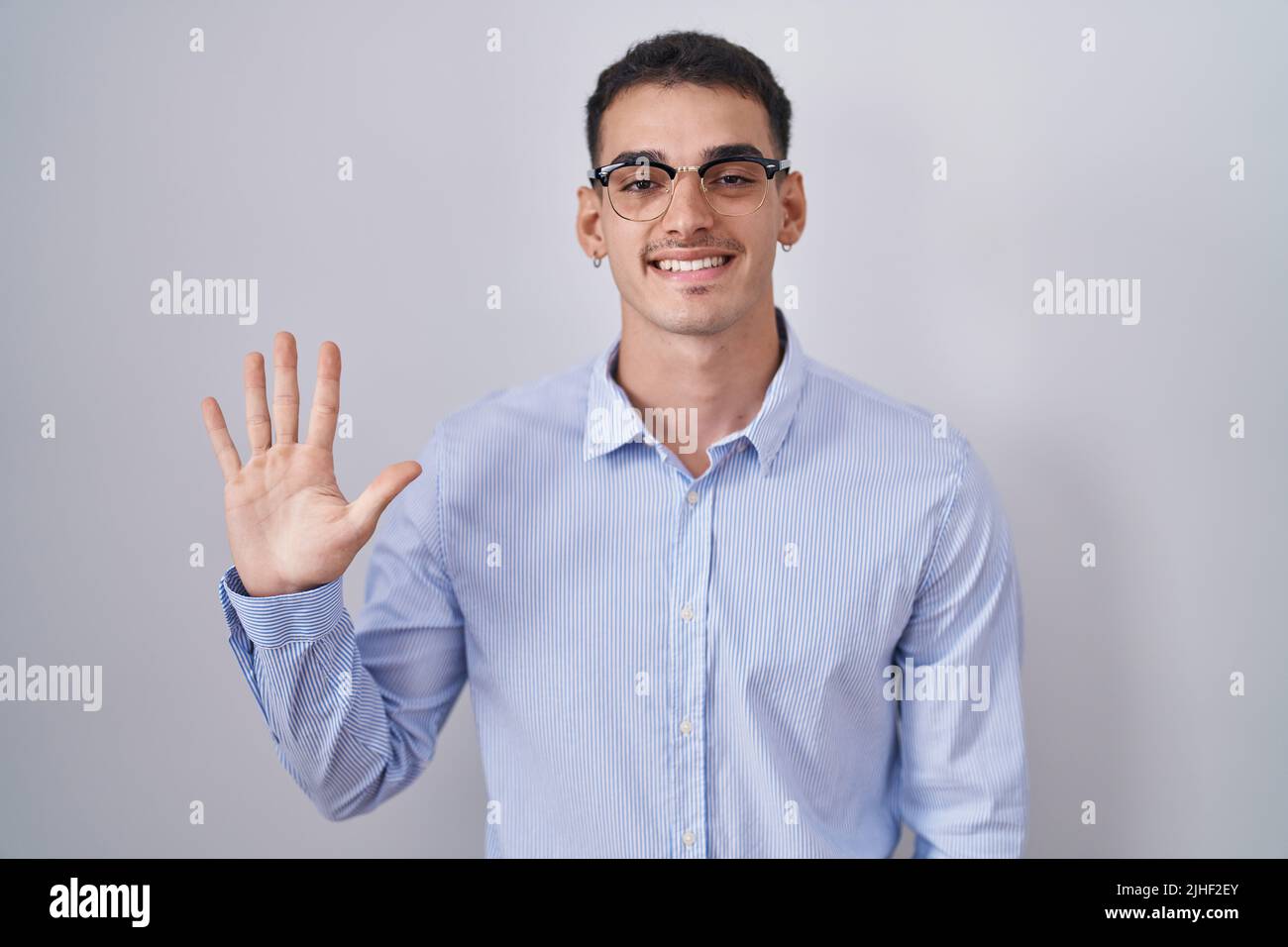 Handsome hispanic man wearing business clothes and glasses showing and ...